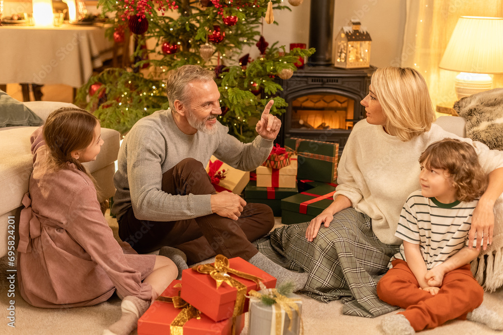 family time on Christmas holiday, sit together on floor near decorated ...
