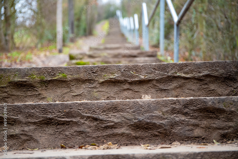 Steep stone steps of a staircase that goes steeply up with metal ...