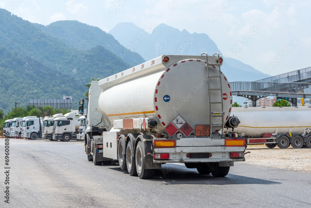 Parking row of trucks with fuel tanks in front of a warehouse and ...