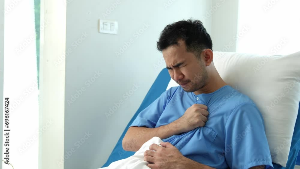Heart attack symptoms An Asian male patient lies in a hospital bed with ...