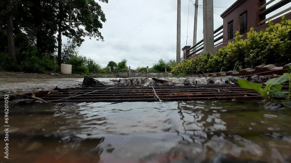 Vidéo Stock Water flows down through the manhole cover. Rain flows into ...