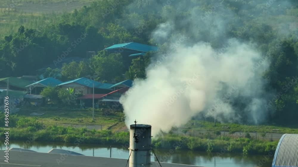 Sinister industrial pipes belch thick white smoke, underscoring the ...
