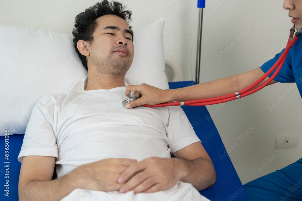 Asian female doctor uses stethoscope to check heartbeat of young Asian ...