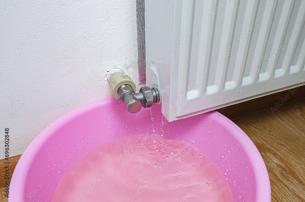 Leaking heating radiator at home. Water pours from the nut threaded ...