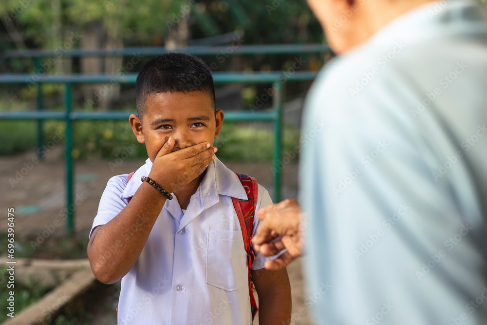 A young elementary student feels embarrassed after being scolded by an ...