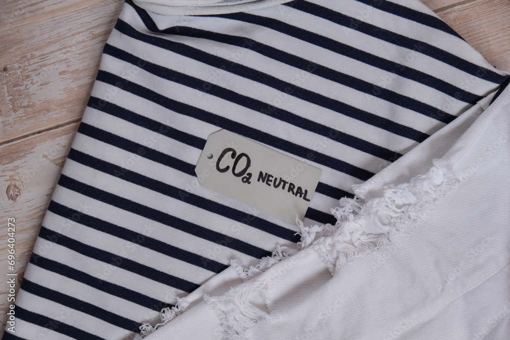 CO2 neutral emission text note on stack of clothes. Ecology nature ...