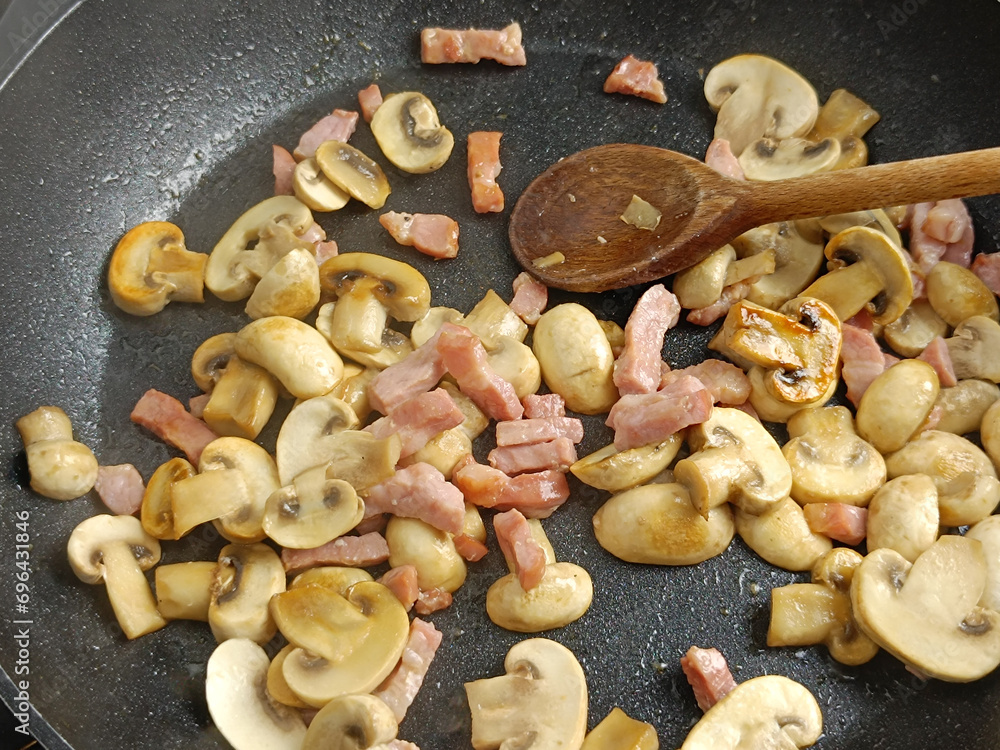 champignons de Paris et lardons de porc en cuisson dans une poêle Stock ...