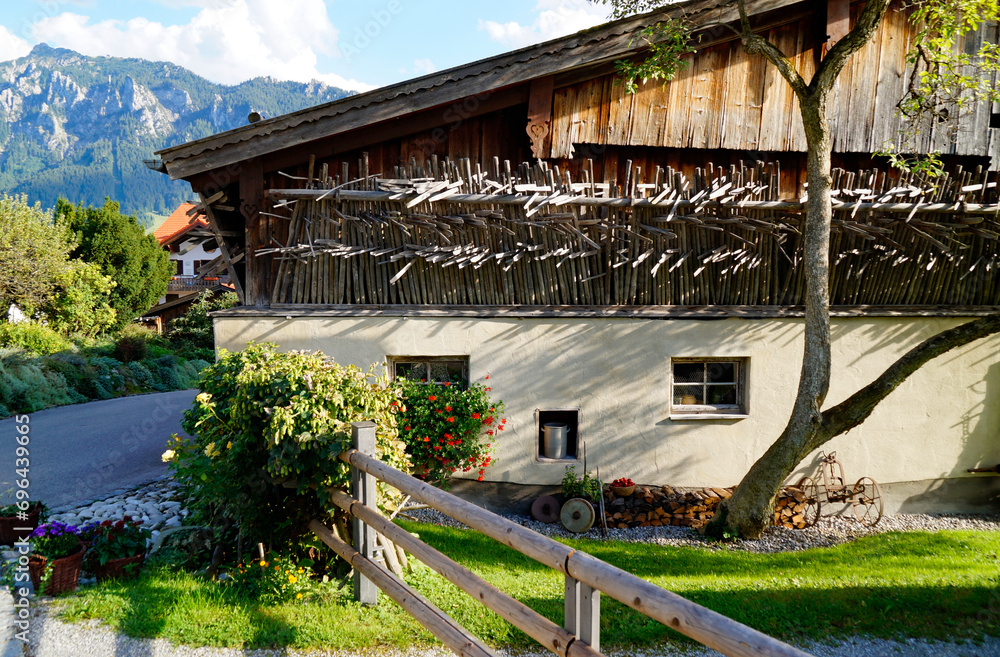 idyllic scene with a traditional Bavarian rustic alpine farmhouse with ...