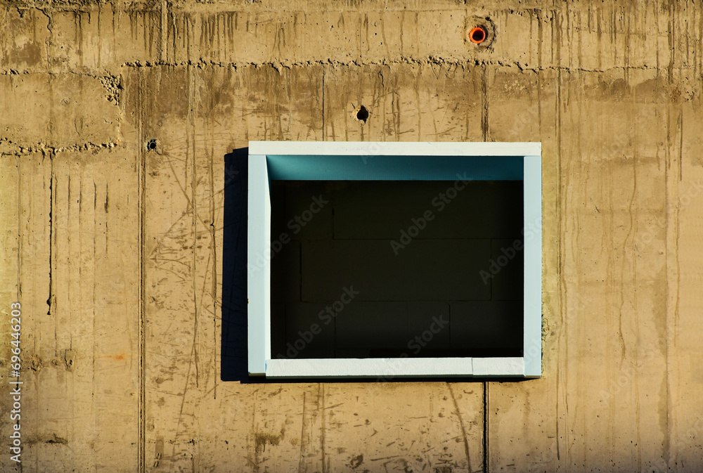 raw window opening and frame in concrete block wall during construction ...