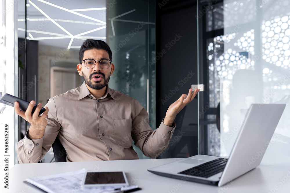 Portrait of a young angry and disappointed Indian man sitting at an ...