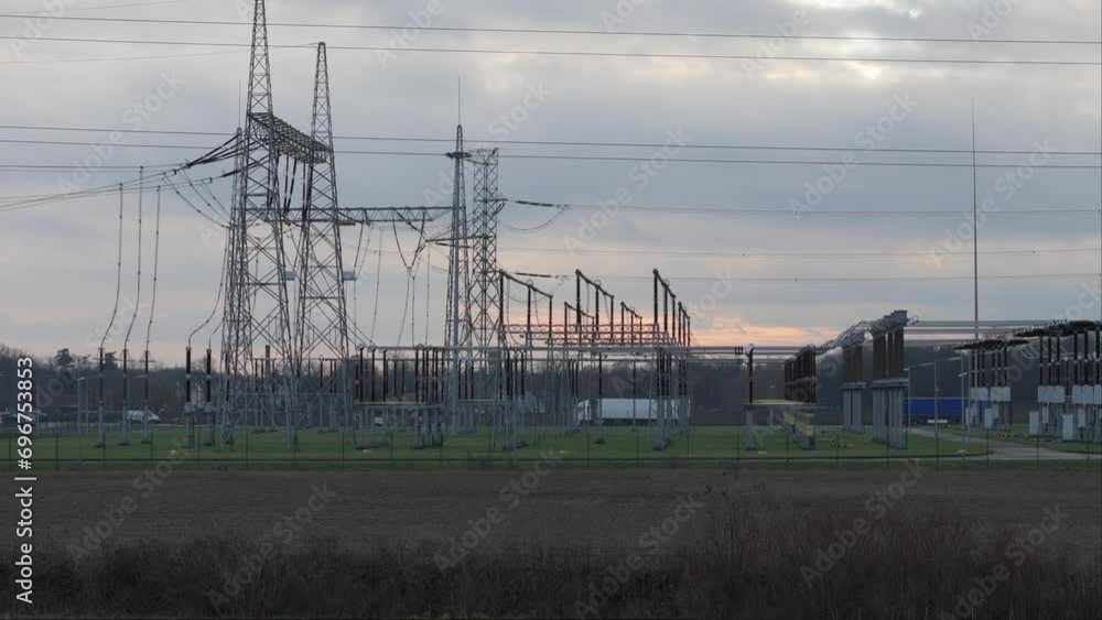 Drone and ground-level footage reveal a transformer station against a ...