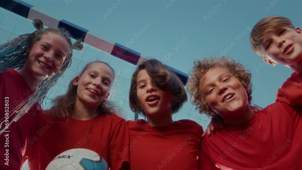 Young football team players with ball in sports uniforms smile holding ...