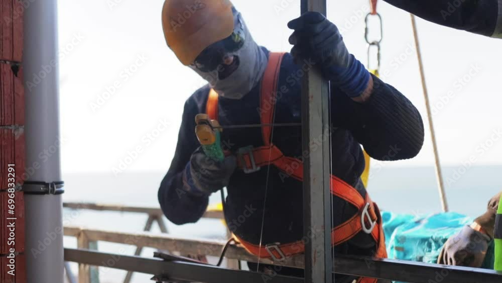 Construction worker performs welding work at height in slow motion ...