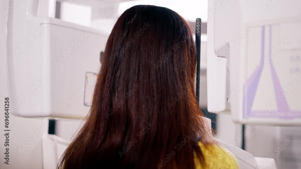 rear view of a woman doing a 3D scan of the nose and mouth in a plastic ...