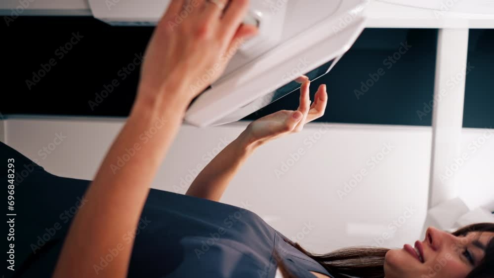 vertical video a female doctor makes a 3D scan of the nose and oral ...