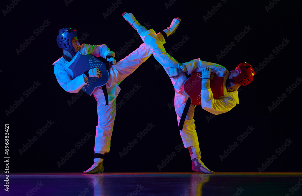 Athletic, strong young men, taekwondo athletes in motion, fighting ...