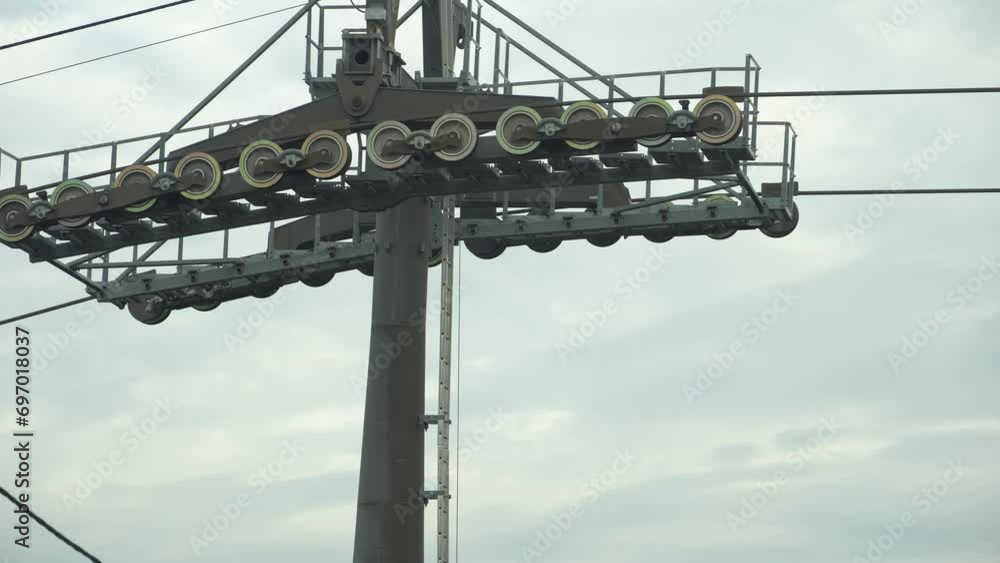Support of ski lift with rotating rollers. Cable car passes by the ...