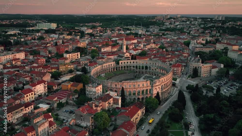 Flying above historic city of Pula at night with evening illumination ...