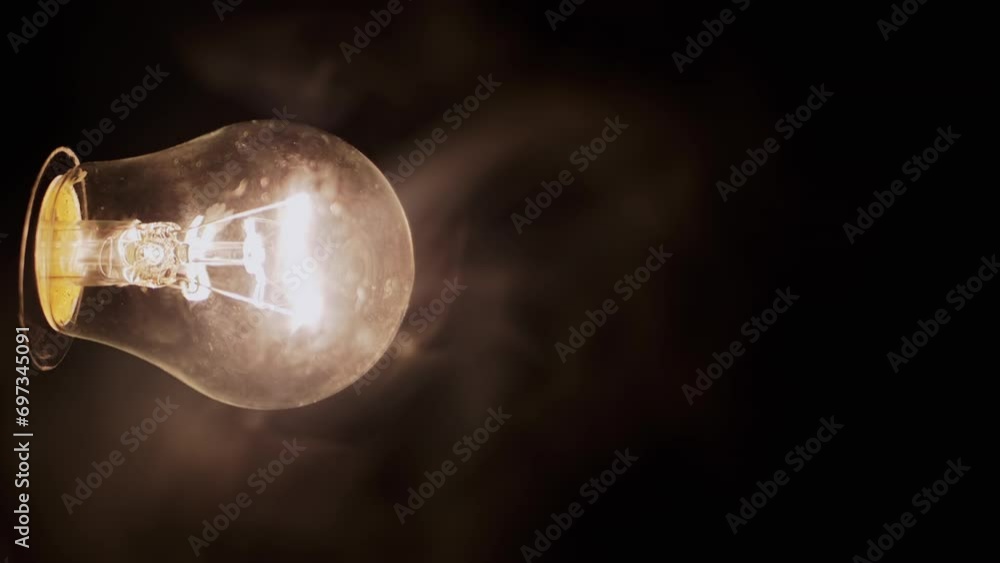 One Glowing Incandescent Light Bulb in Thick Smoke on Black Background ...