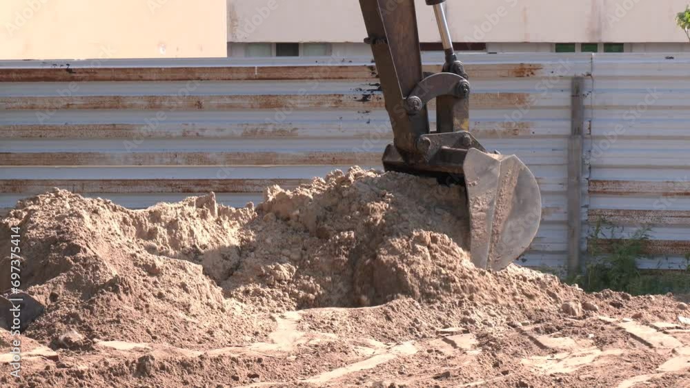 Closeup bucket of backhoe digging the soil at construction site ...