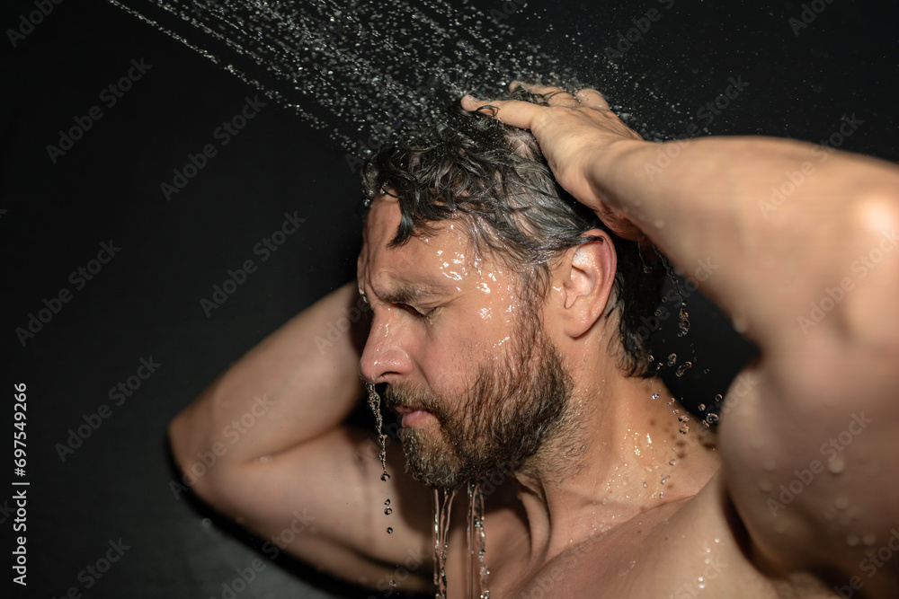 Millennial man washing hair in bath. Guy bathing shower head in bathtub ...