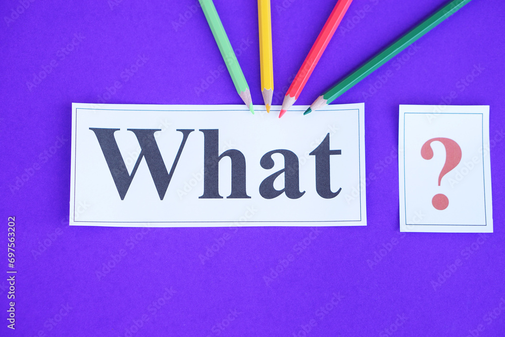 Paper cards with text What and question marks. color pencils on purple ...