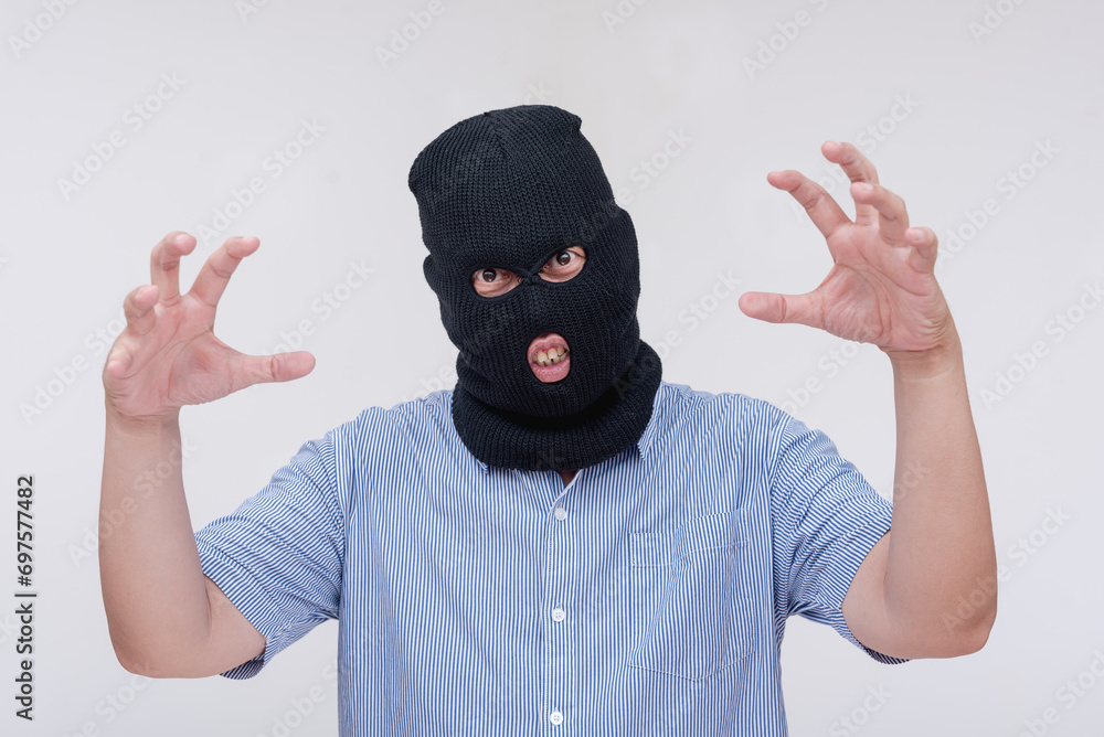 A scary and unhinged evil man wearing a black ski mask makes a ...