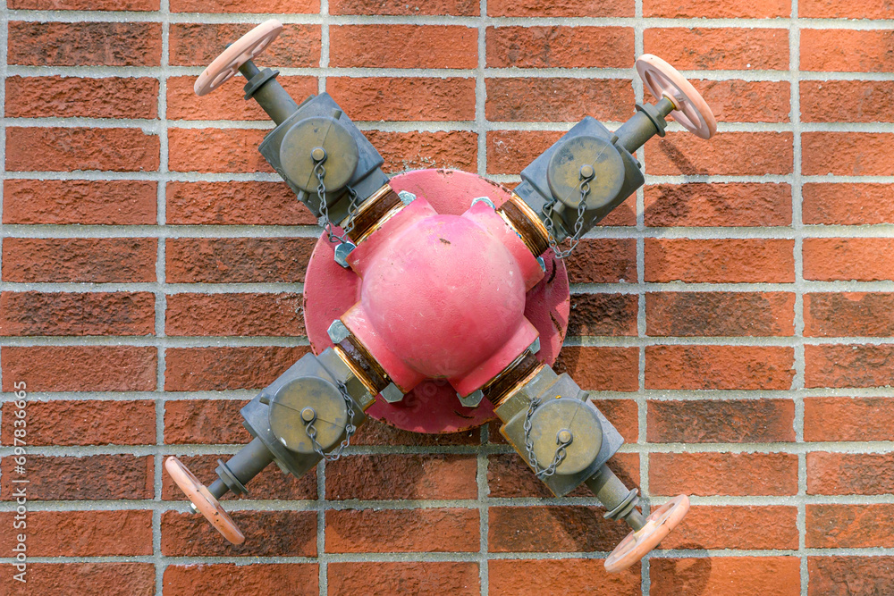 Four Way Fire Hose Connection on an Exterior Brick Wall. Stock Photo ...