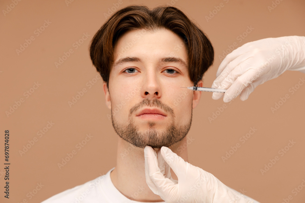 Handsome bearded young man getting under eye injections. Isolated on ...