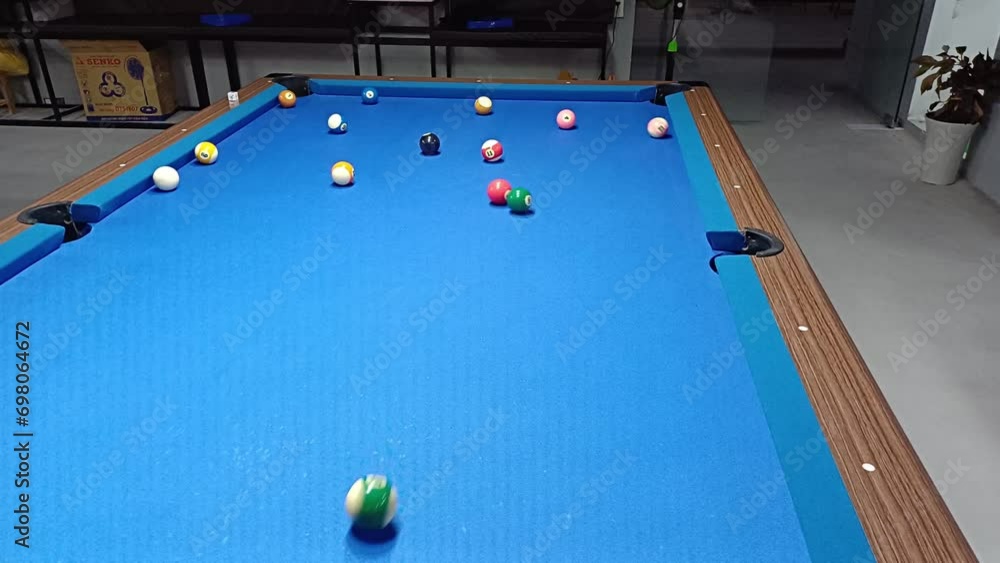 People playing 8-ball pool billiards on blue table. Pool is a ...