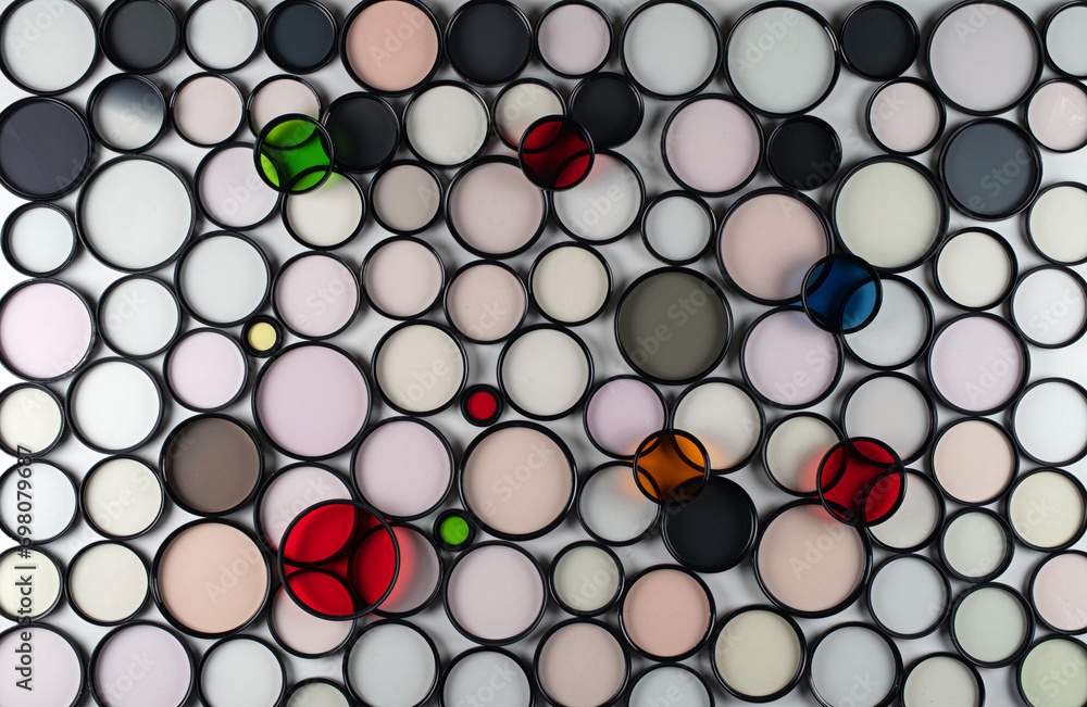 Glass round filters of different colors and sizes are isolated on a ...
