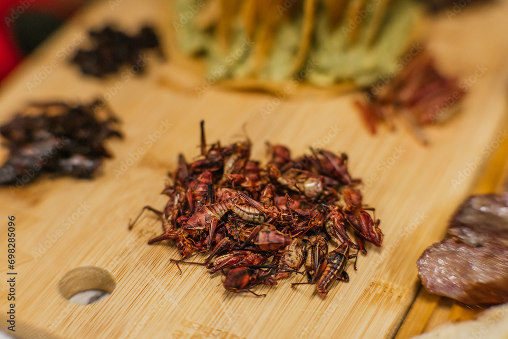 Delicious insect board with guacamole and toast, with grasshoppers ...