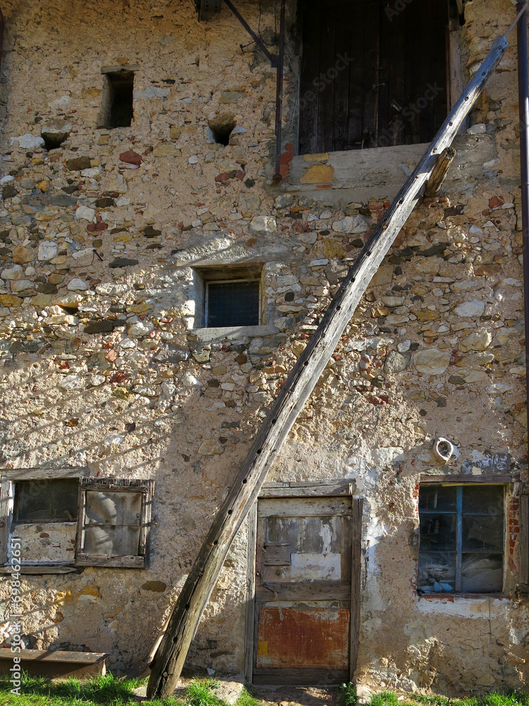 long wooden ladder placed obliquely leaning on the wall of the ancient ...