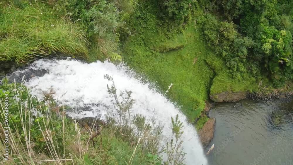 Looking down from the top of tropical waterfall flow, full HD panning ...
