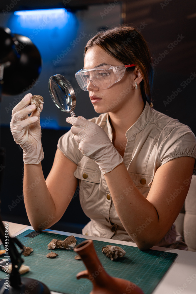 Archaeologist studying an ancient artifact using a magnifying glass and ...
