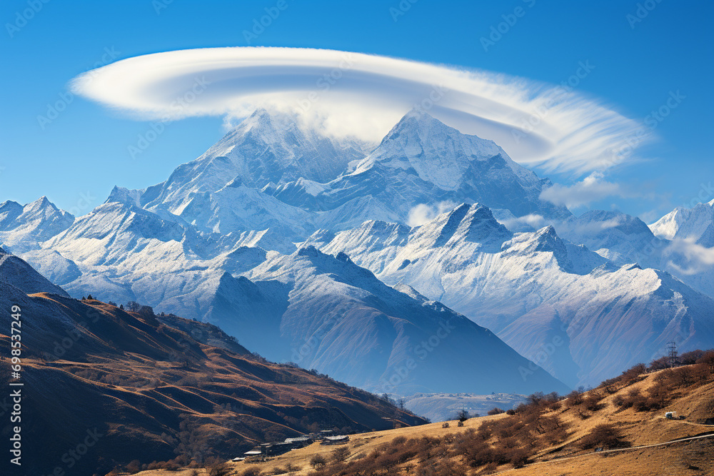 Lenticular cloud formation over mountain peaks, creating a striking and surreal atmospheric ...