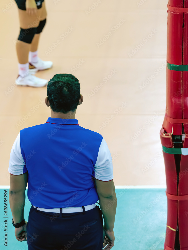 Back view of male second volleyball referee stands and assists the main ...