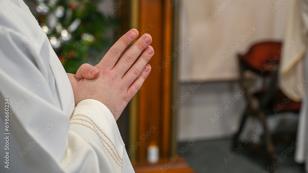 Poster Catholic priests in liturgical vestments praying with hands ...