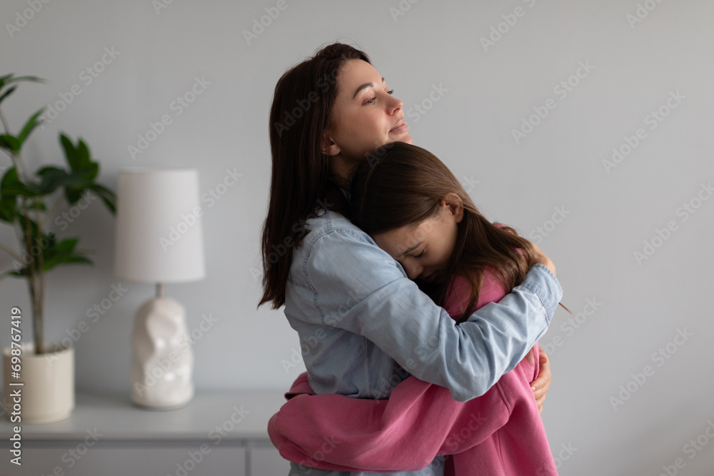 Mother hugging and comforting crying teen daughter, showing love support to sad child, embracing ...