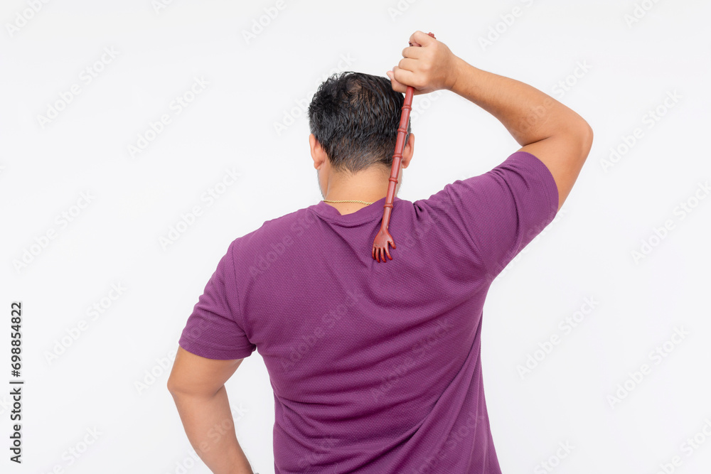 A middle aged man using a backscratcher to scracth and relieve an itch ...