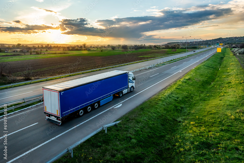 Large Transportation Truck on a highway road through the countryside ...