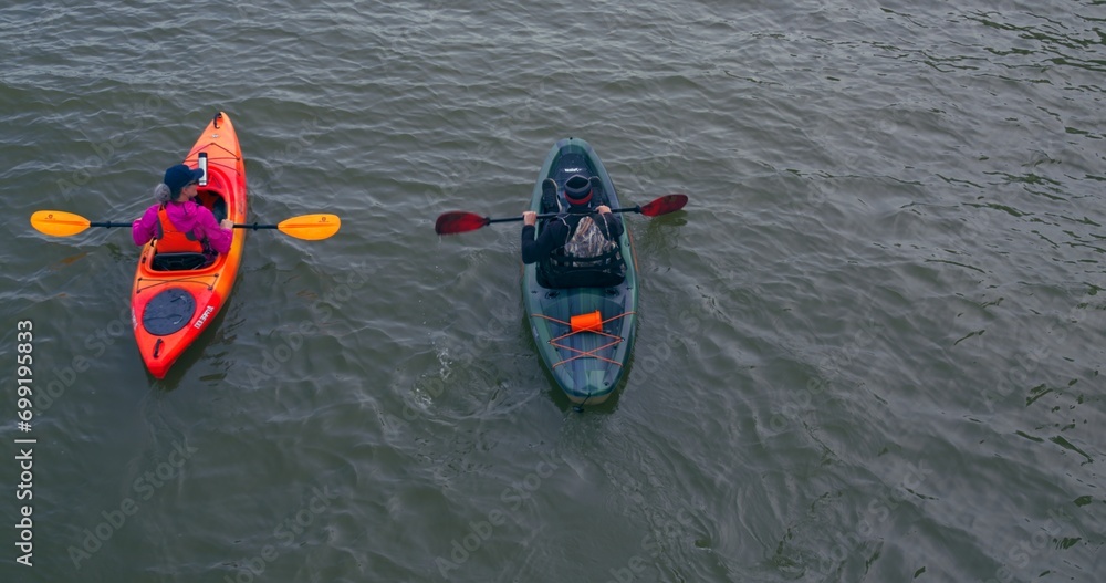 Two people in kayaks glide over Lake Ontario top view cinematic shot ...