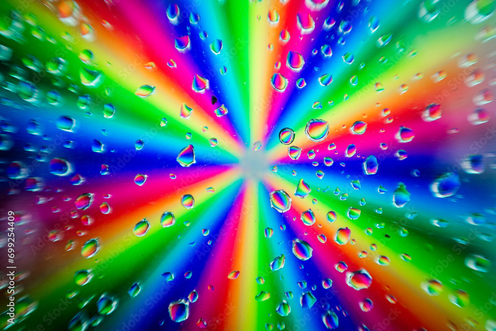 A radial burst of vibrant rainbow colors blurred behind a pattern of ...