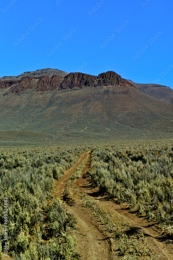 Dirt road in foreground disappears then reappears in on lower slope of ...