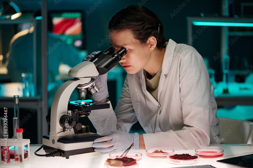 Scientist comparing different kinds of lab-grown meat by looking at its ...
