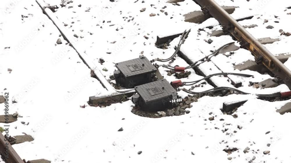 railway track switch mechanisms covered with light snow. The mechanical ...