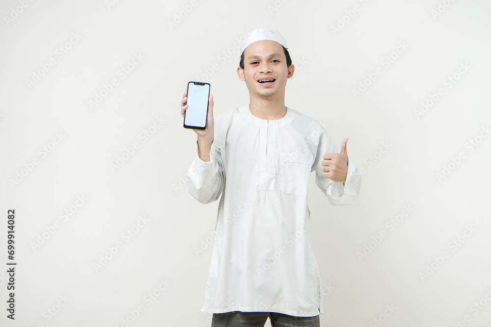 Asian Muslim man holding smartphone and showing thumb up gesture on ...