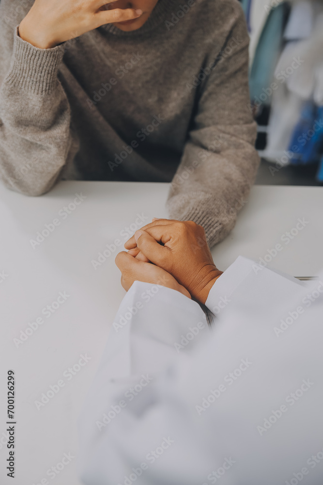 Doctor and patient sitting near each other at the table in clinic ...