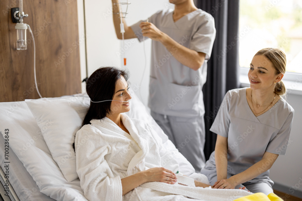 Nurse has a conversation with female patient lying in bed during ...