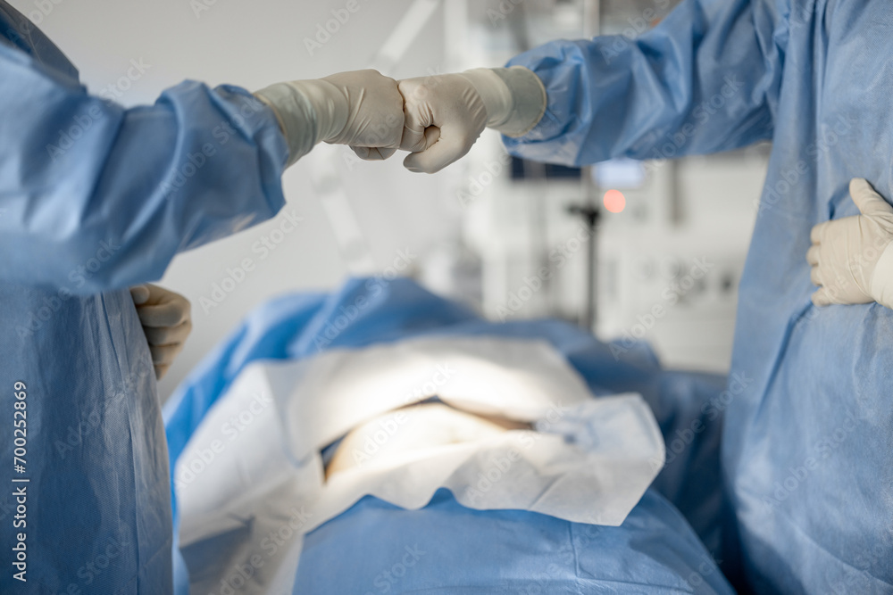 Two surgeons giving five each other ready for an operation, close-up ...